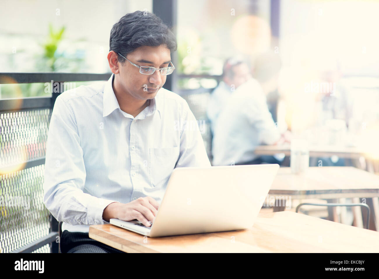Candid Asian Indian man using laptop computer at outdoor cafe Stock ...