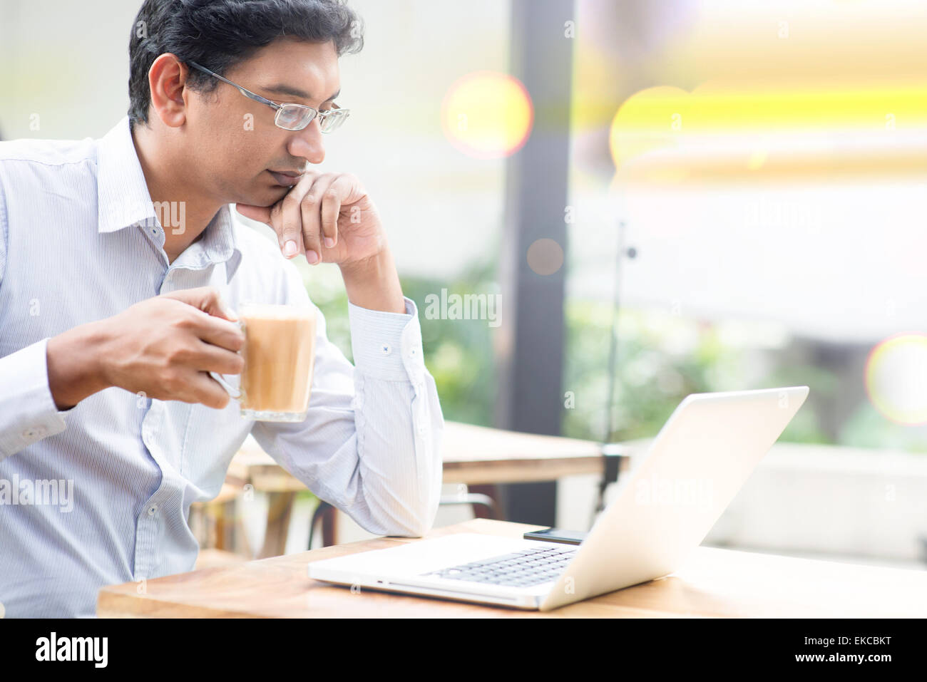 Man using laptop computer while drinking a cup hot milk tea, outdoor ...