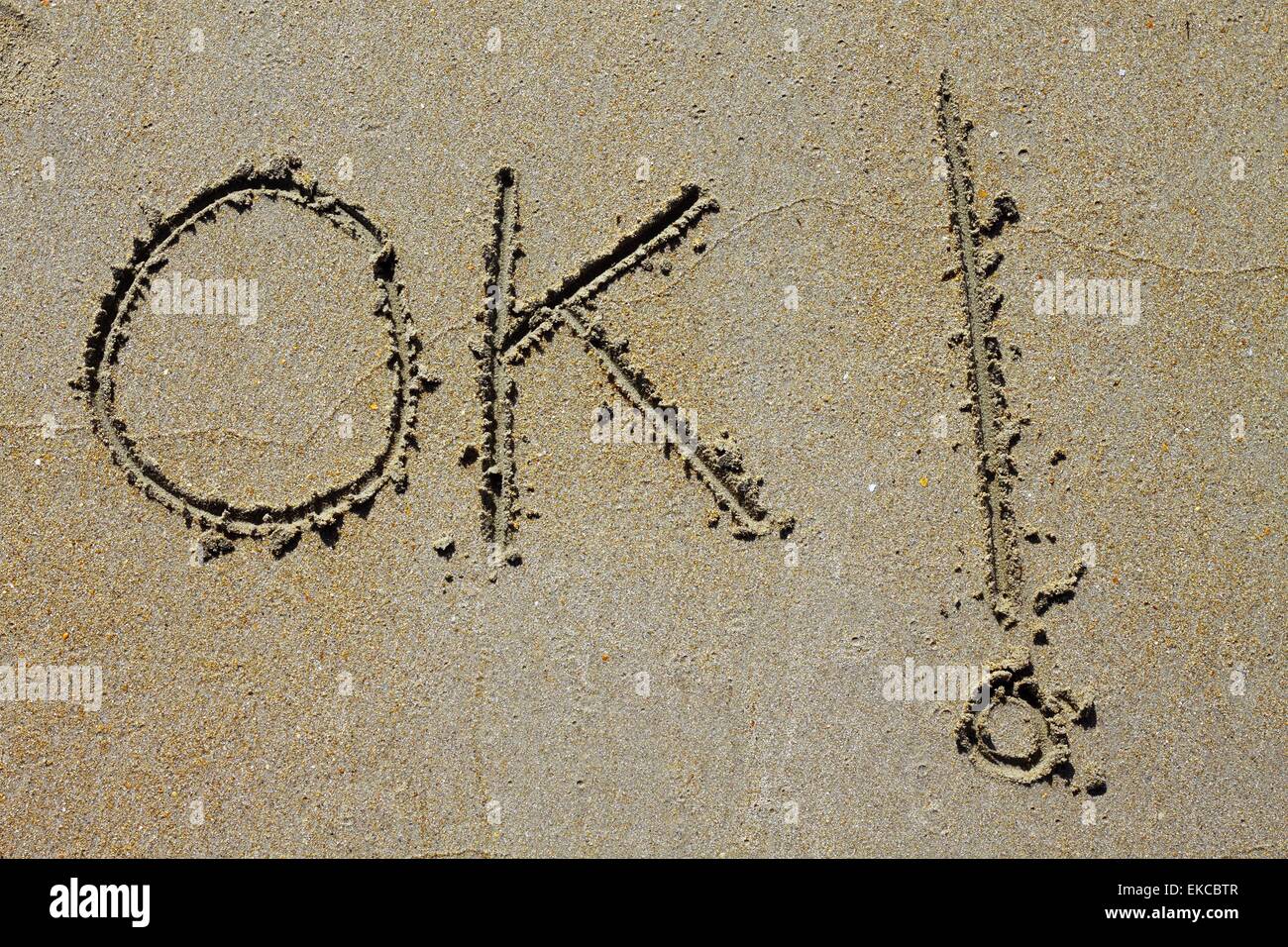 ok word spell written on beach wet sand Stock Photo - Alamy