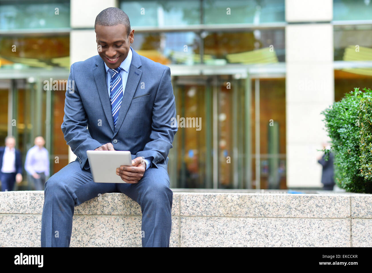 Relaxed businessman using his tablet pc Stock Photo - Alamy