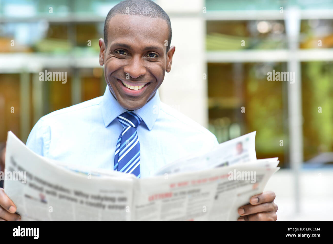 Smiling executive holding newspaper Stock Photo - Alamy