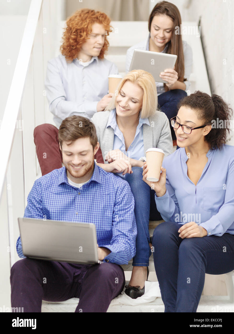 team with laptop and tablet pc on staircase Stock Photo - Alamy