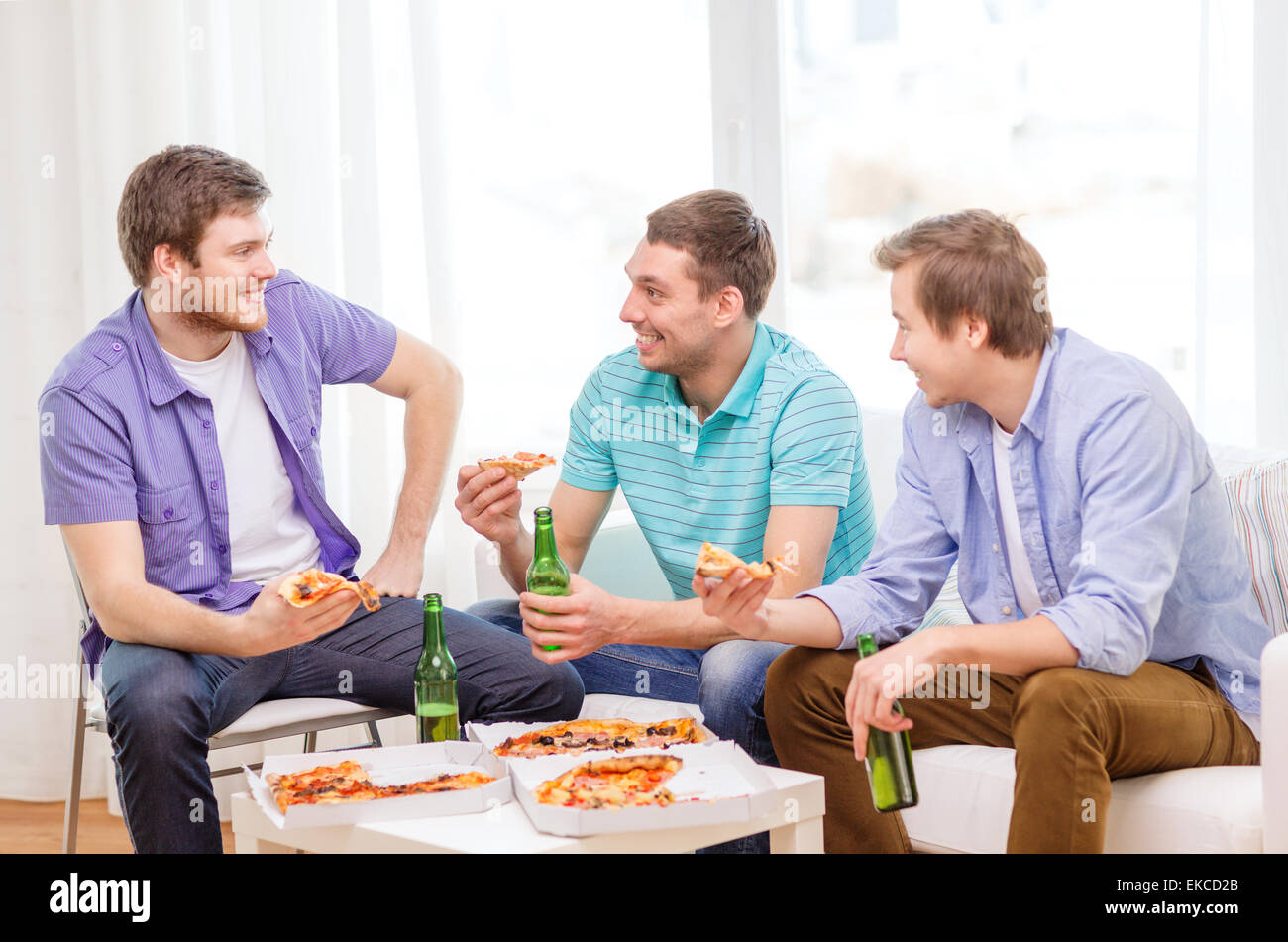 smiling friends with beer and pizza hanging out Stock Photo - Alamy