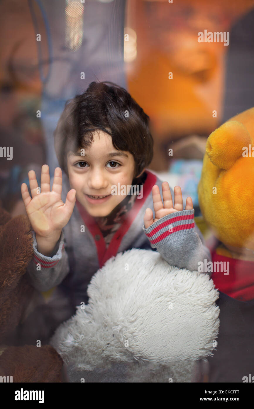 Smiling boy looking through window Stock Photo - Alamy