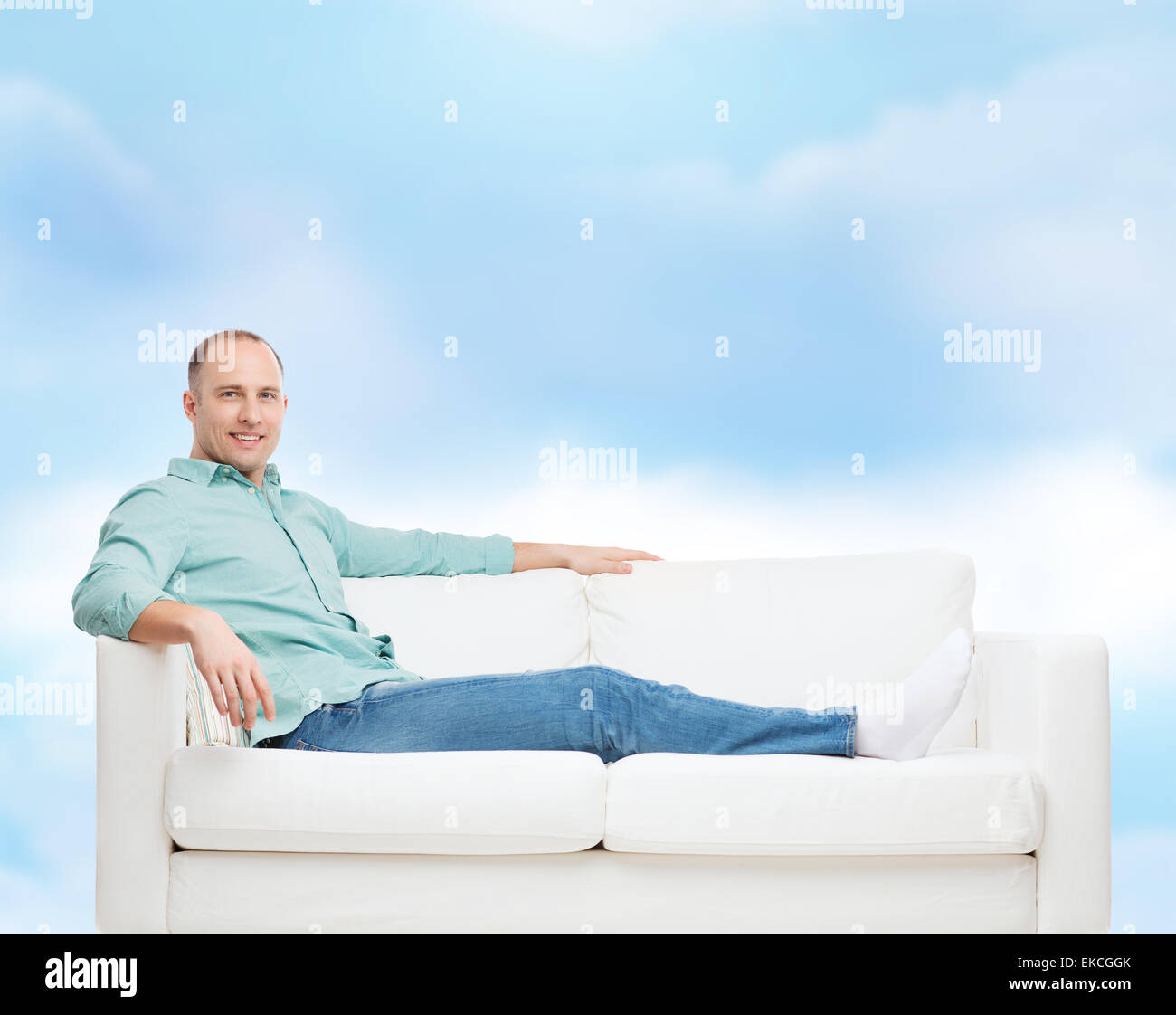 smiling man lying on sofa Stock Photo - Alamy