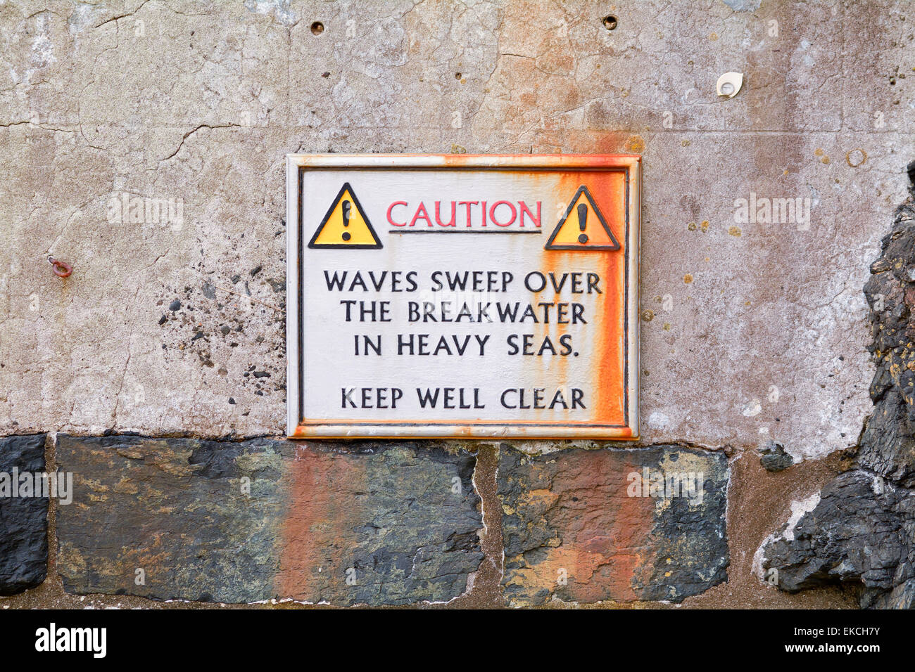Warning sign on harbour wall - Caution Waves sweep over Breakwater ...