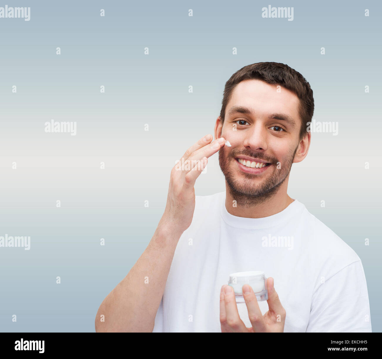 beautiful smiling man applyin cream Stock Photo - Alamy