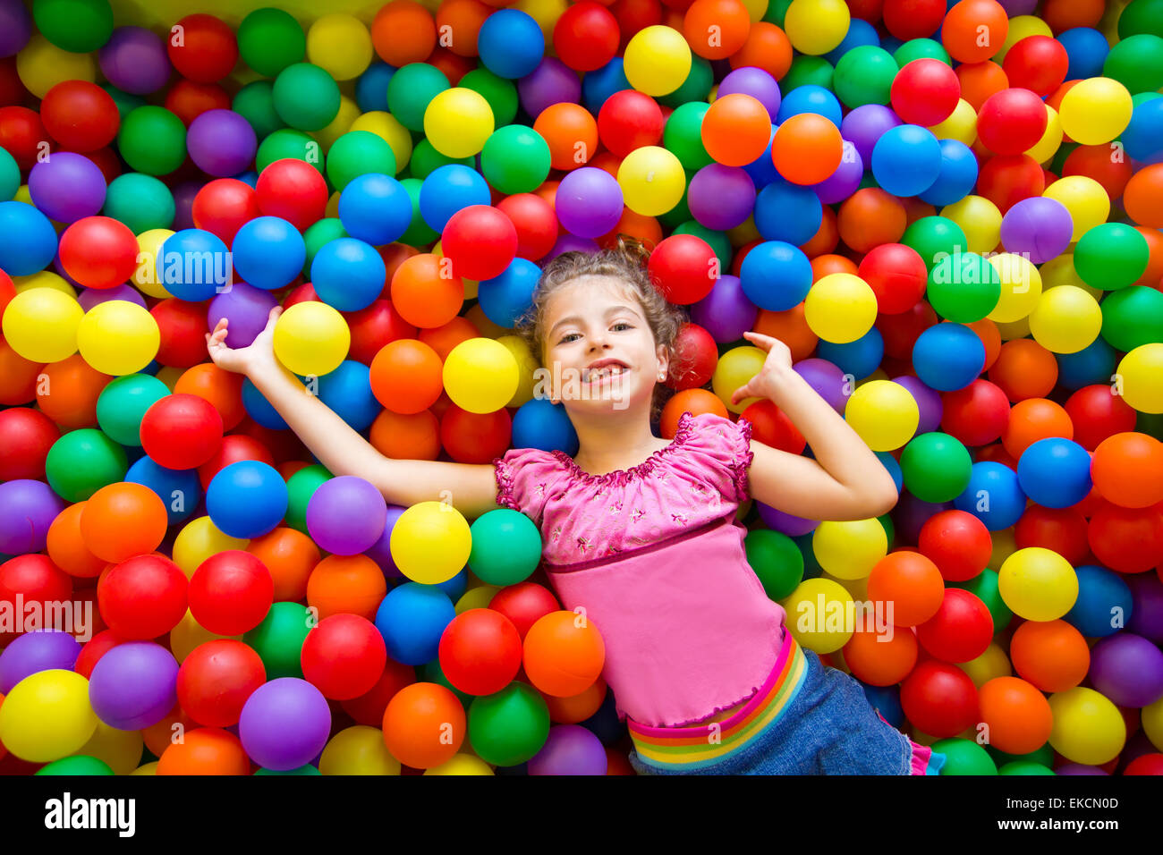 child girl on colorful balls playground high view Stock Photo - Alamy