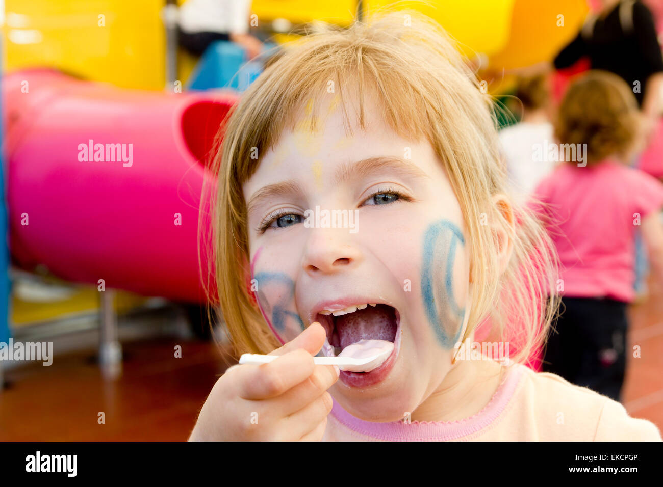 eating spoon funny girl playground smiling blond Stock Photo - Alamy