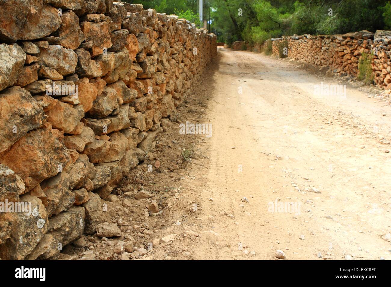 masonry stone wall fence around sand soil track Stock Photo - Alamy
