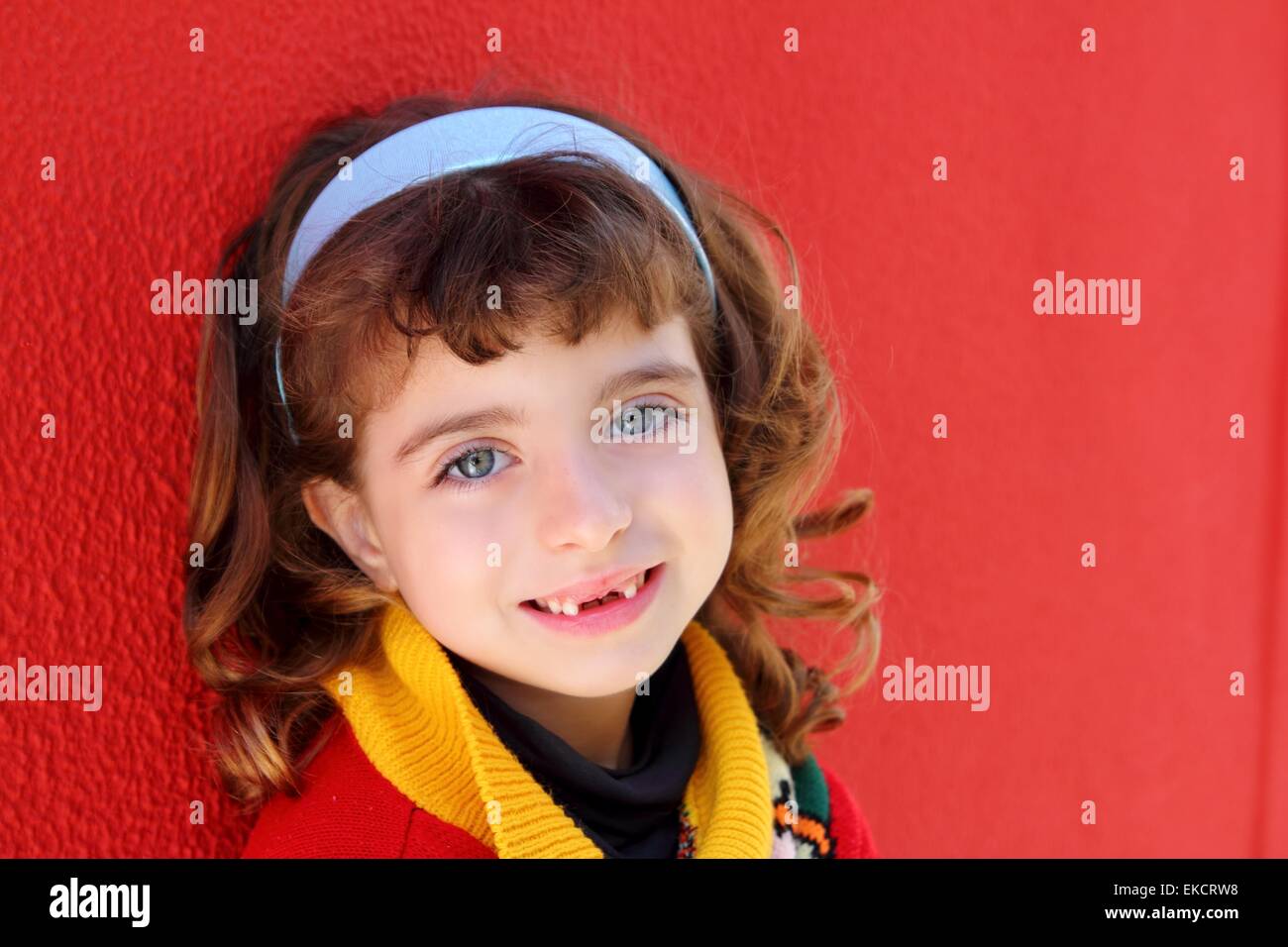 smiling little girl indented front teeth smile on red Stock Photo - Alamy