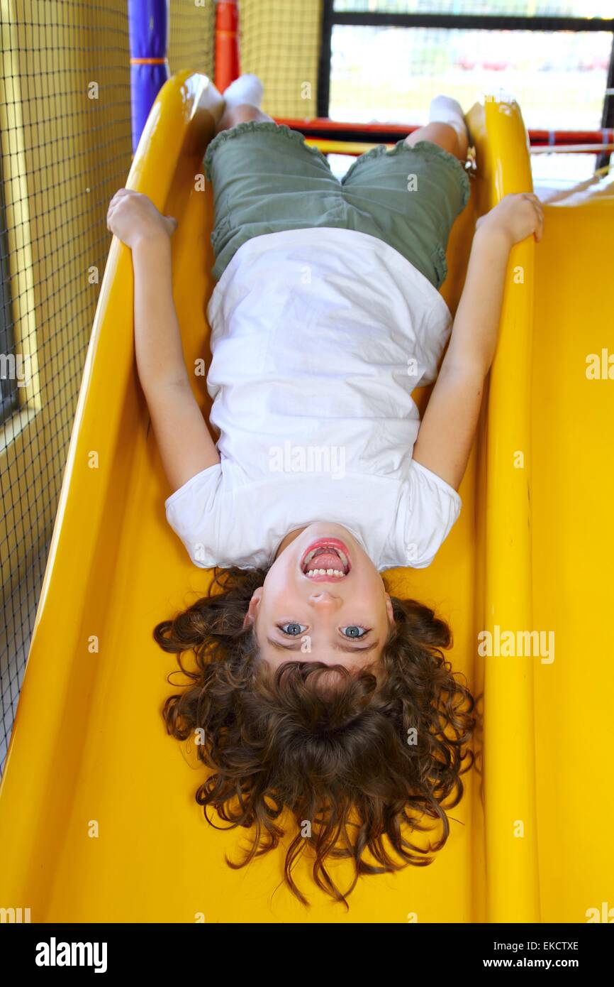 upside down little girl on playground slide laughing Stock Photo - Alamy