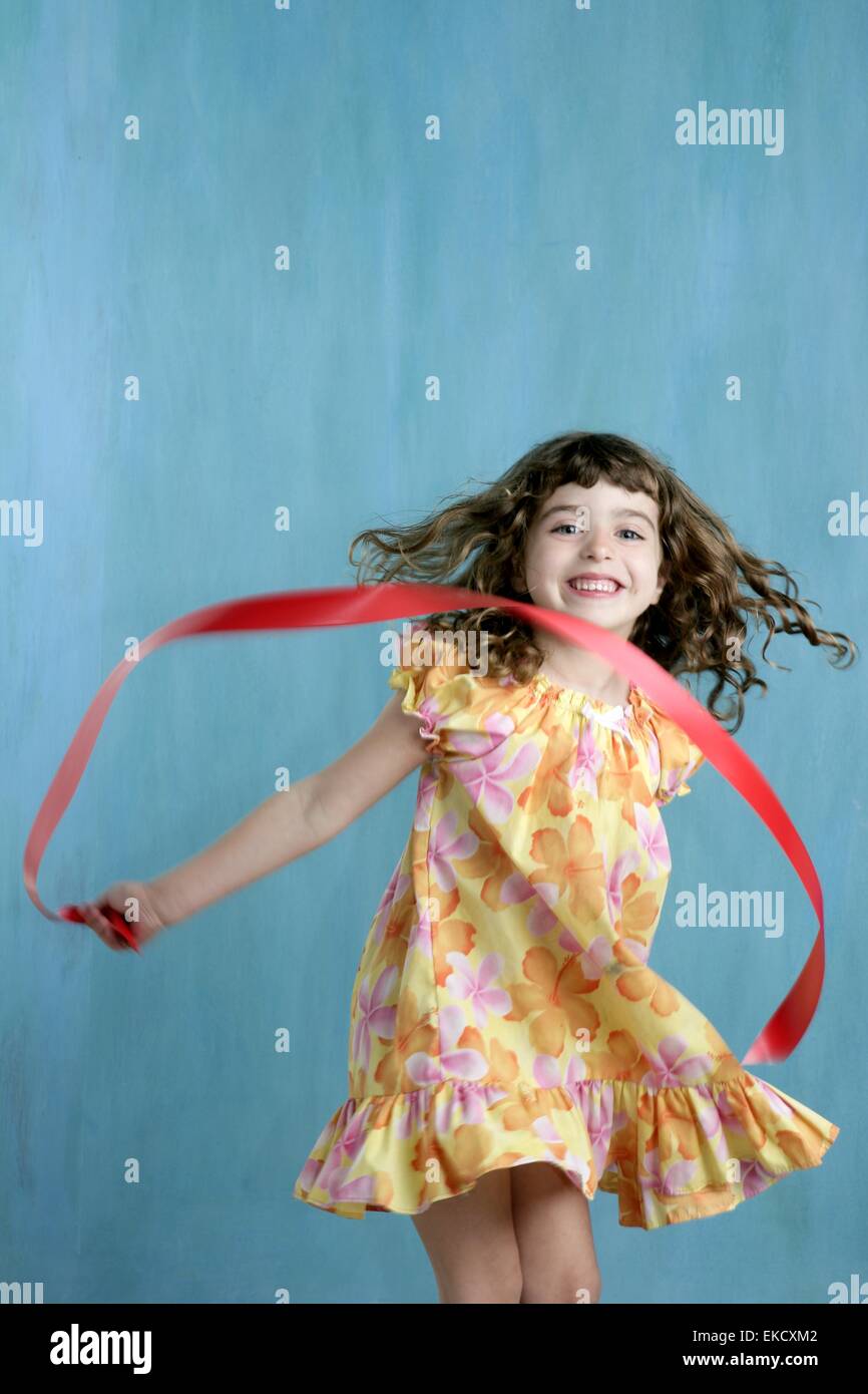 little girl red ribbon tape dancing over green Stock Photo - Alamy