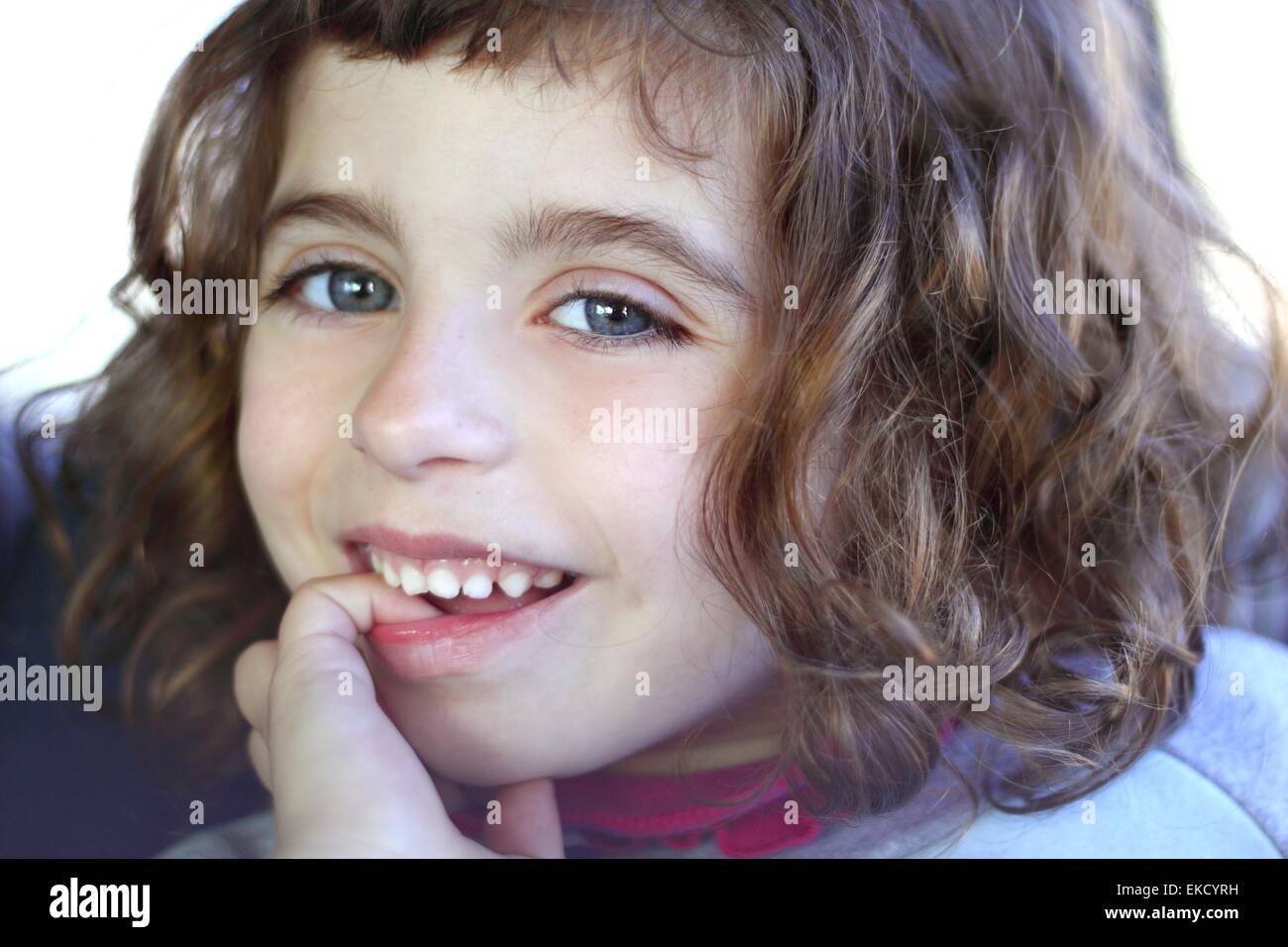little firl smiling shy biting finger blue eyes Stock Photo - Alamy