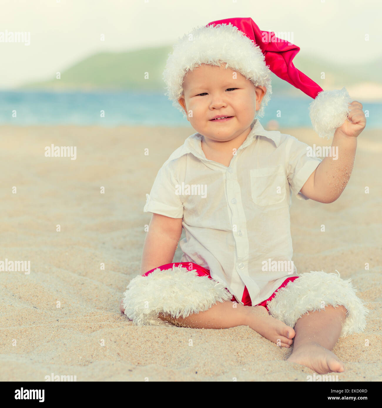 Little Santa boy on the beach Stock Photo - Alamy