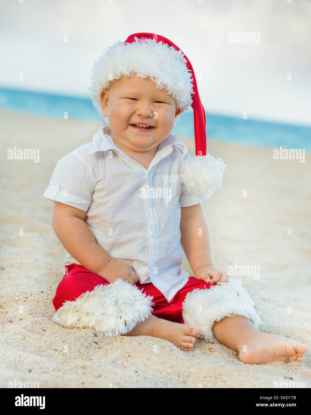 Little Santa boy on the beach Stock Photo - Alamy