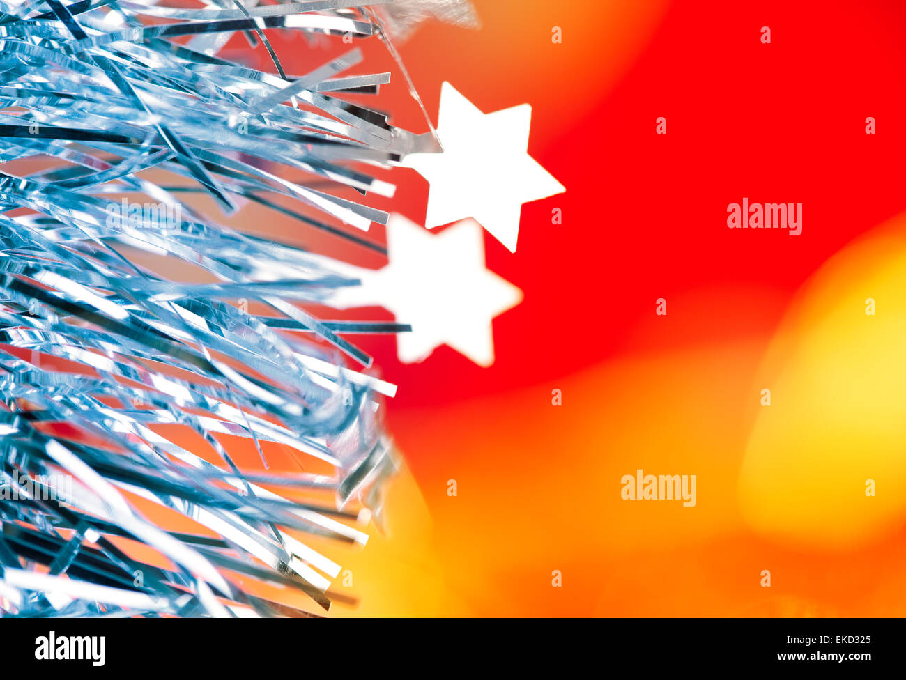 Christmas tinsel stars silver blue on red Stock Photo - Alamy