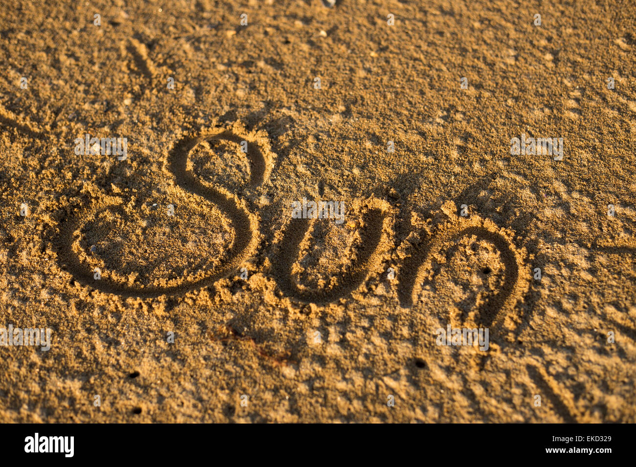 The word 'Sun' written in golden beach sand Stock Photo - Alamy