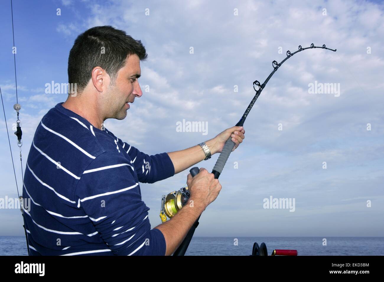 Angler fisherman fighting big fish rod and reel Stock Photo - Alamy