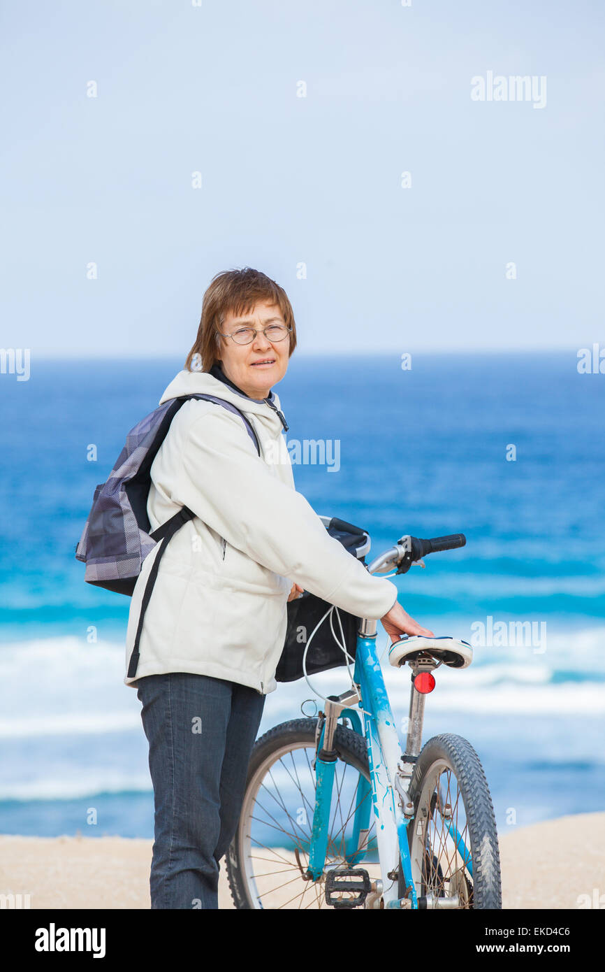 A nice senior lady riding a bike on the beach Stock Photo - Alamy