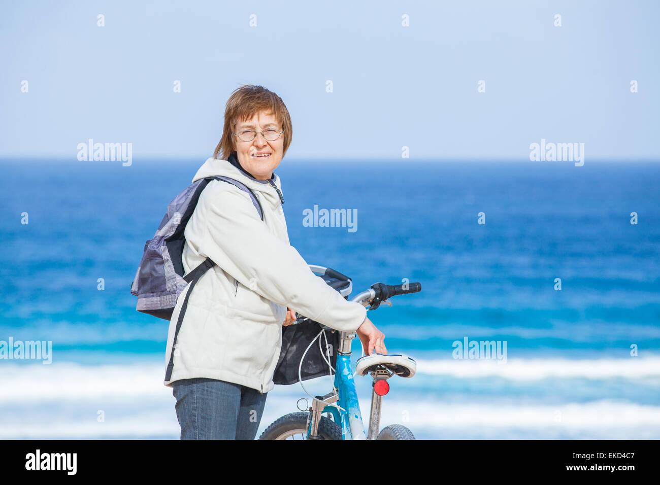 A nice senior lady riding a bike on the beach Stock Photo - Alamy