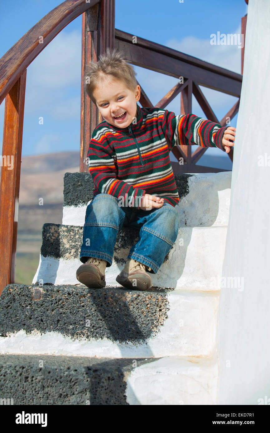 Happy little boy sitting on stairs Stock Photo - Alamy