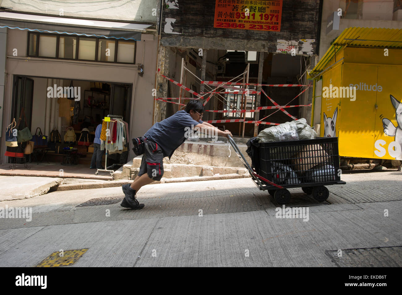 Asian worker pushing cart up a steep Hong Kong street Stock Photo - Alamy
