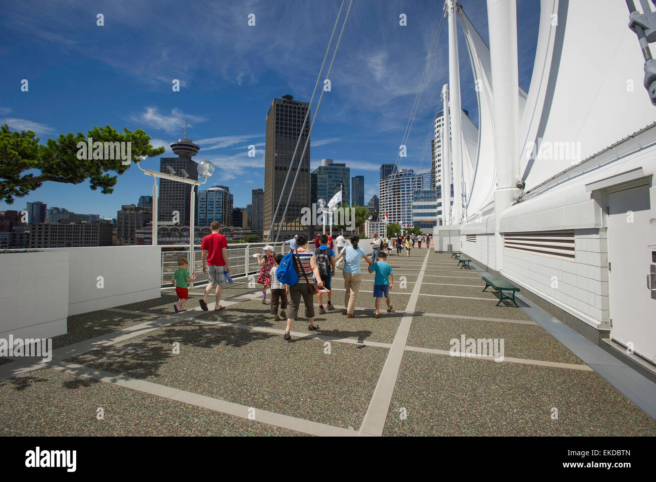 Tourists walking along the promenade of Canada Place cruise ship ...