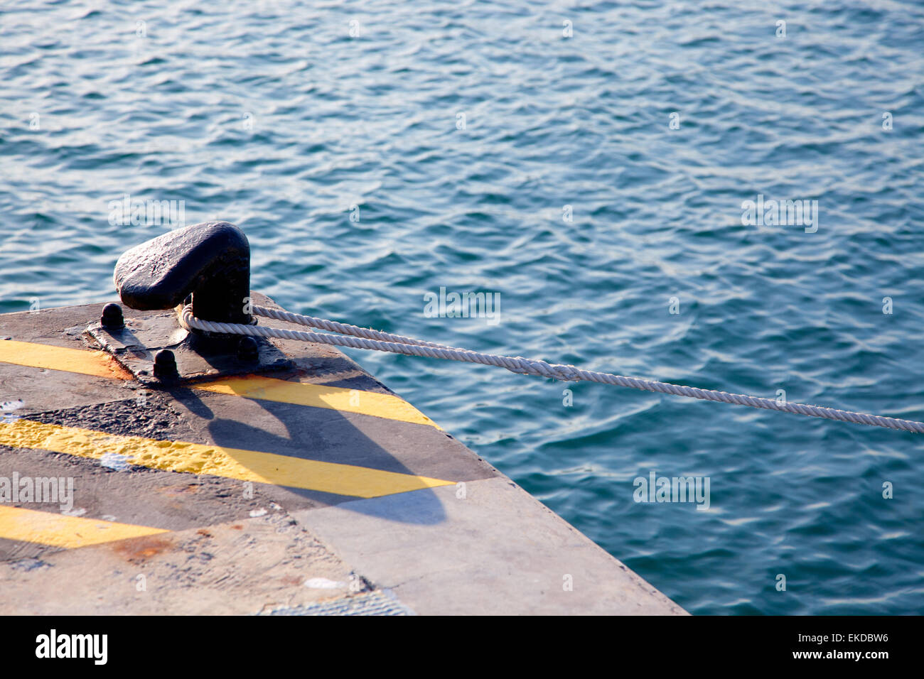 Bollard in port with rope looped around Stock Photo - Alamy