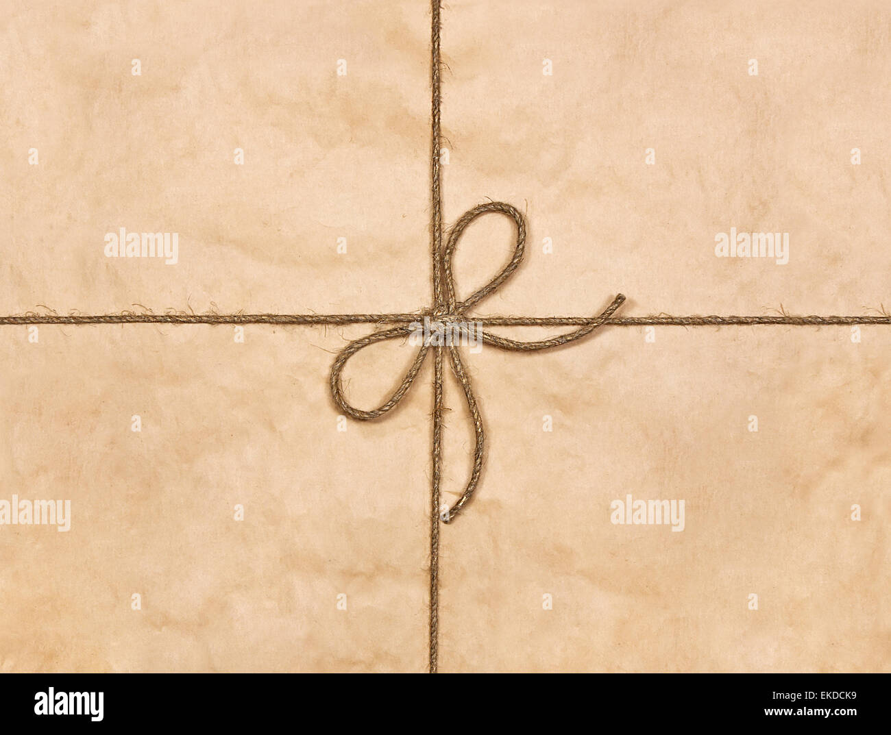 String tied in a bow on a brown recycled paper Stock Photo - Alamy