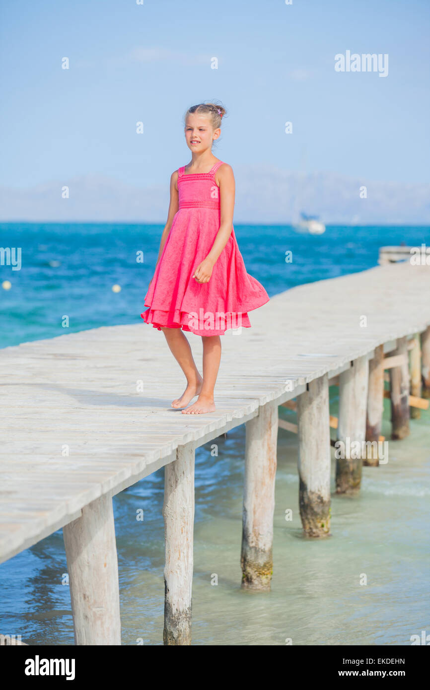 Girl walking on jetty Stock Photo - Alamy