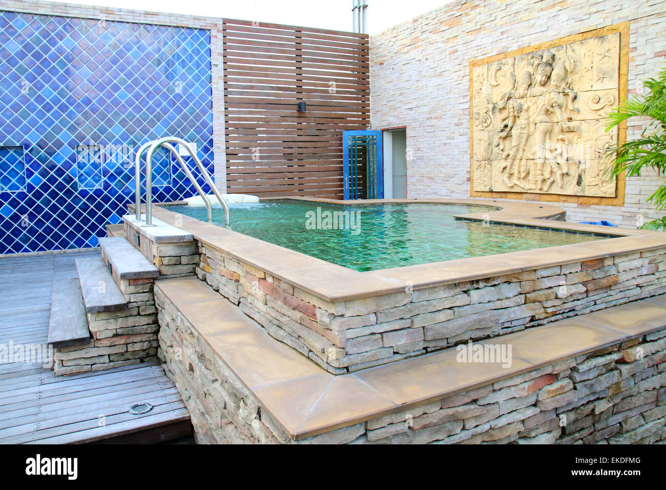 outdoor jacuzzi with thai stone carving wall Stock Photo - Alamy