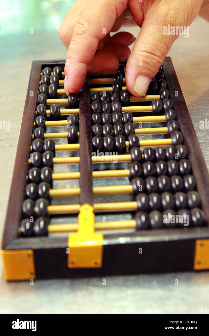 Abacus with old man's hand Stock Photo - Alamy