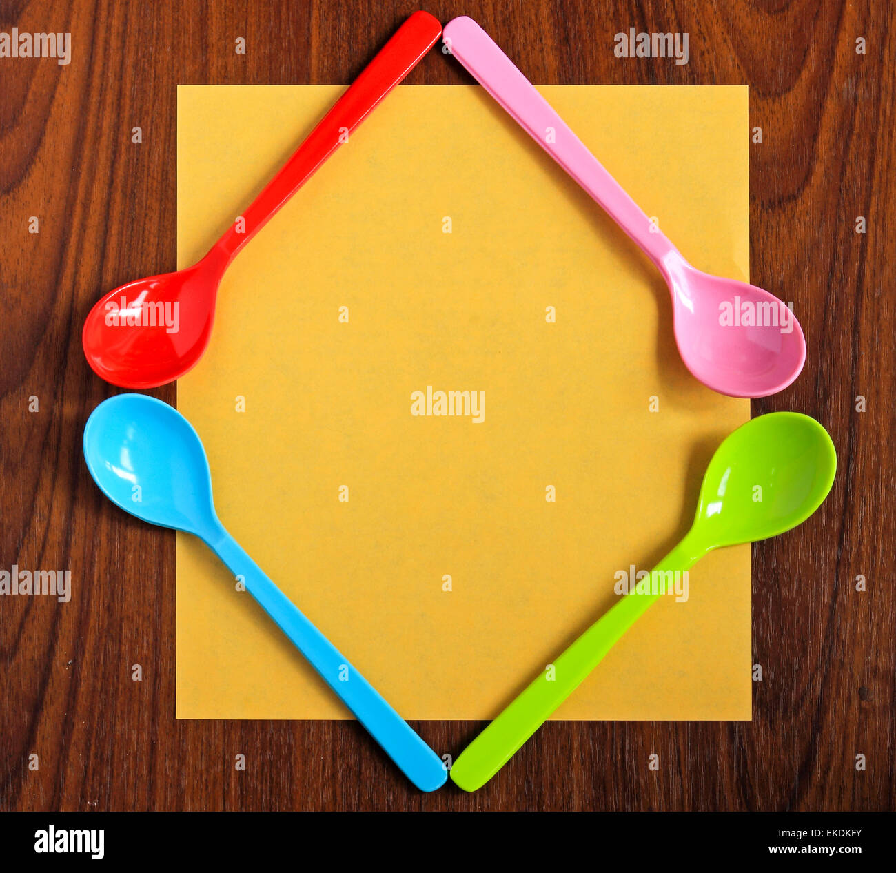 colorful spoons with yellow paper on wooden background Stock Photo - Alamy