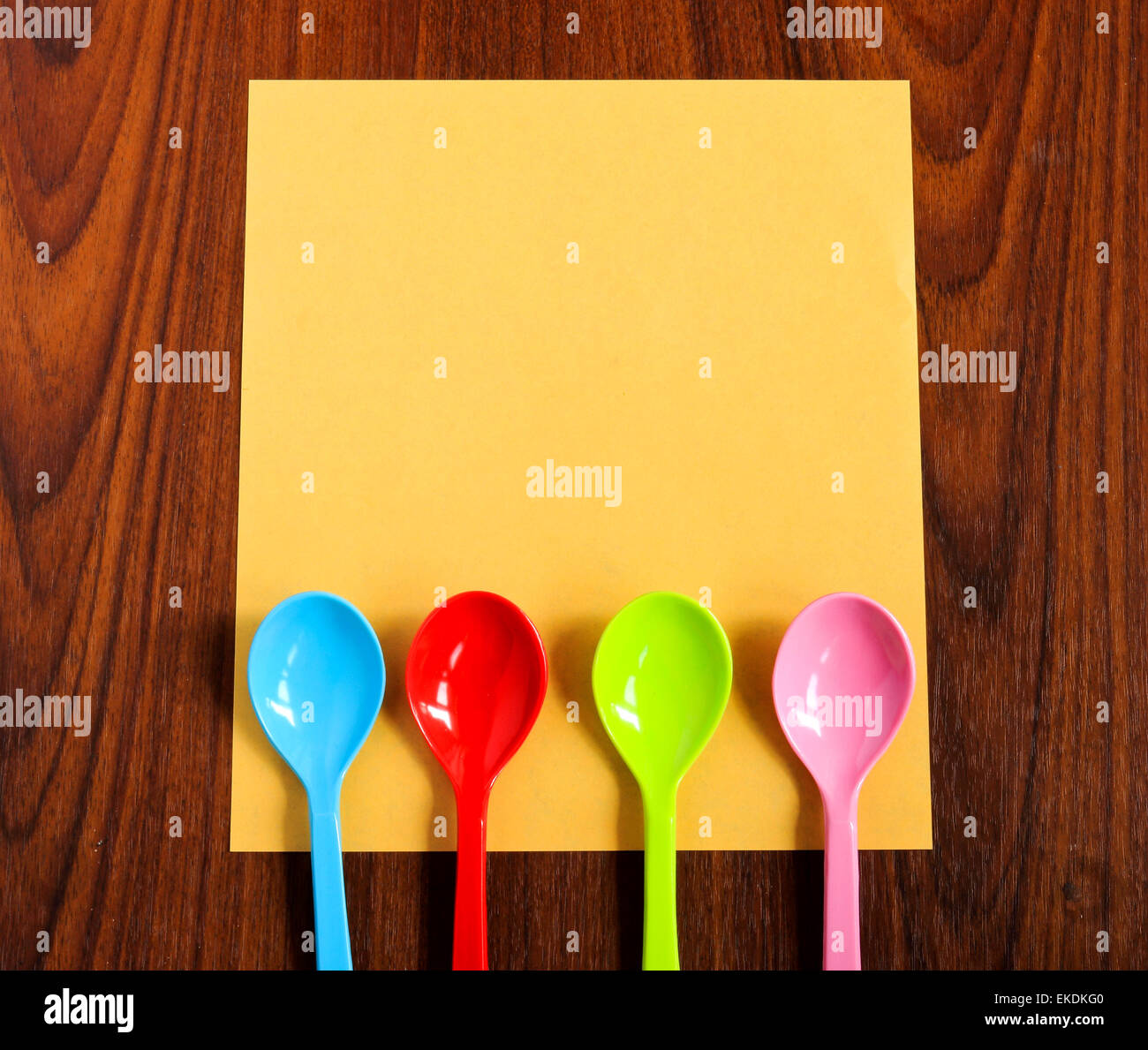 colorful spoons with yellow paper on wooden background Stock Photo - Alamy
