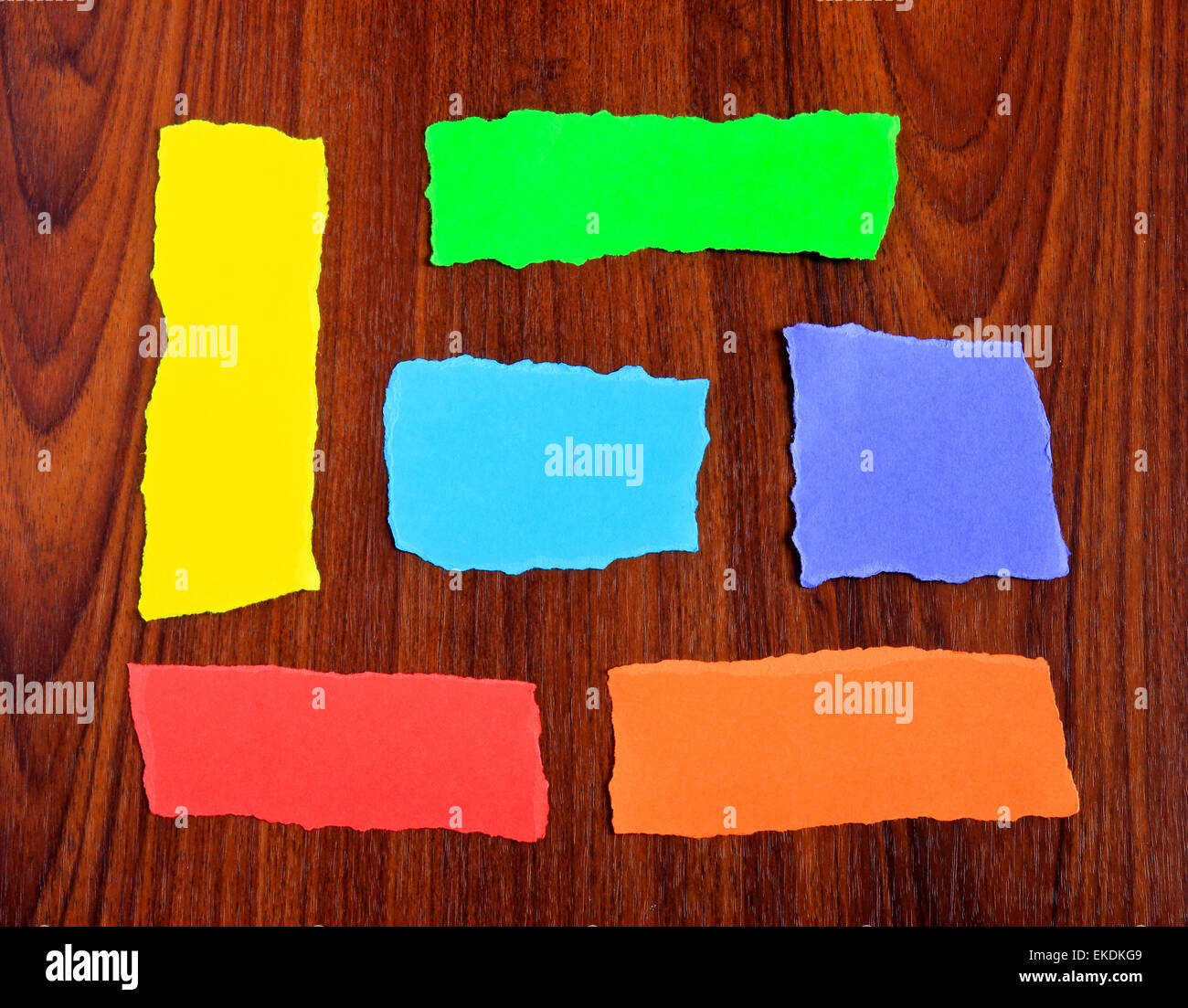 Colorful ripped paper on wooden background Stock Photo - Alamy