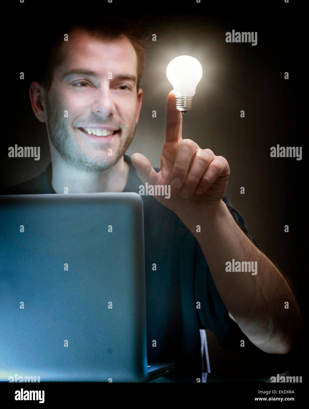 Young Man With Laptop And Idea Light Bulb Stock Photo - Alamy
