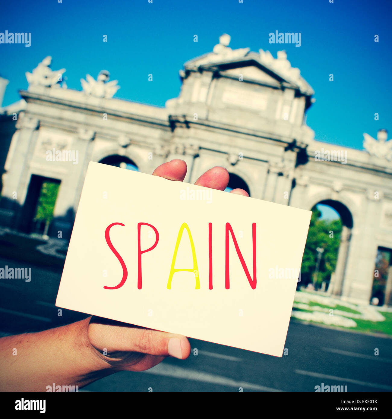 a young caucasian man holds a signboard with the word Spain written in ...