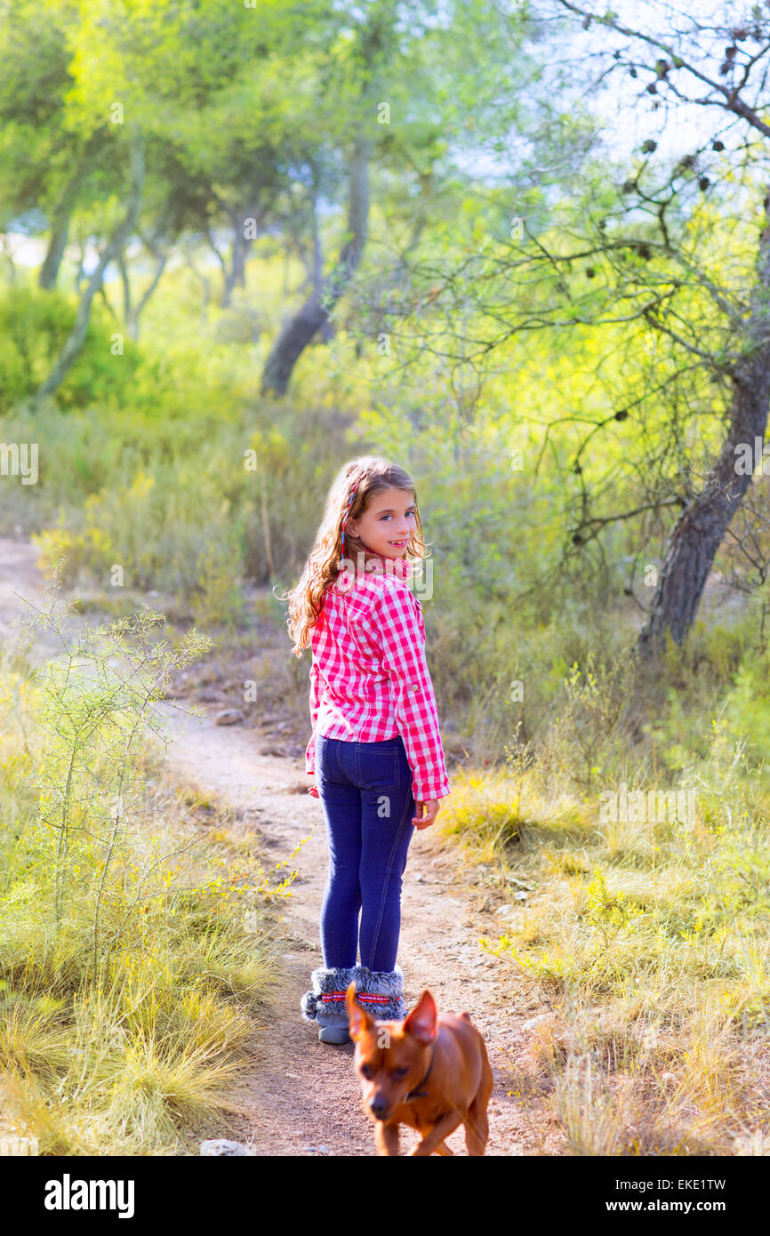 children girl walking in the pine forest with dog Stock Photo - Alamy