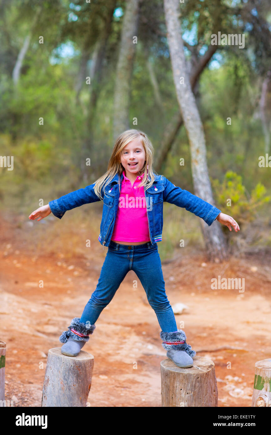 kid girl climbing tree trunks with open arms Stock Photo - Alamy