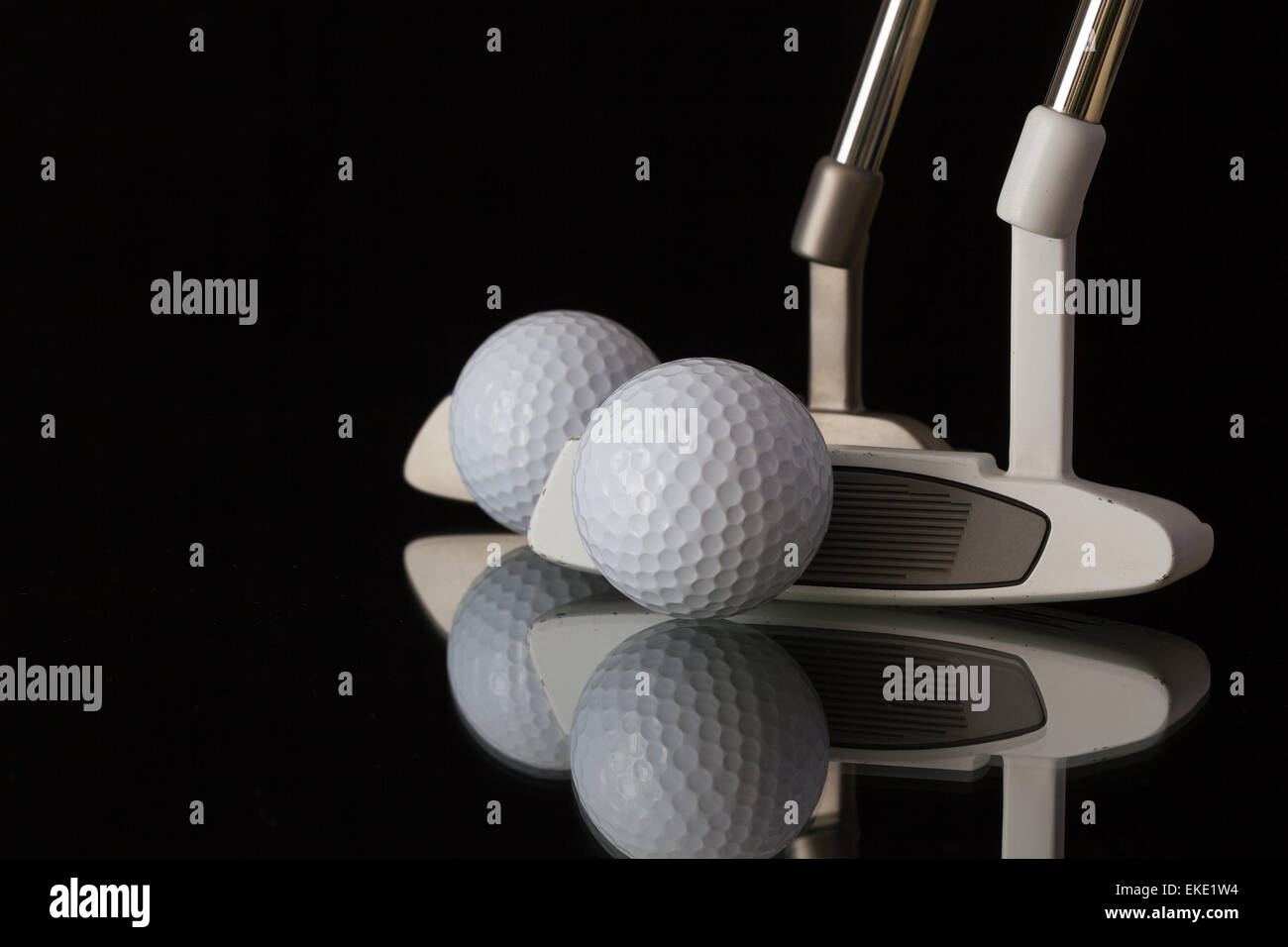Two different golf putters and balls on a black glass desk Stock Photo ...