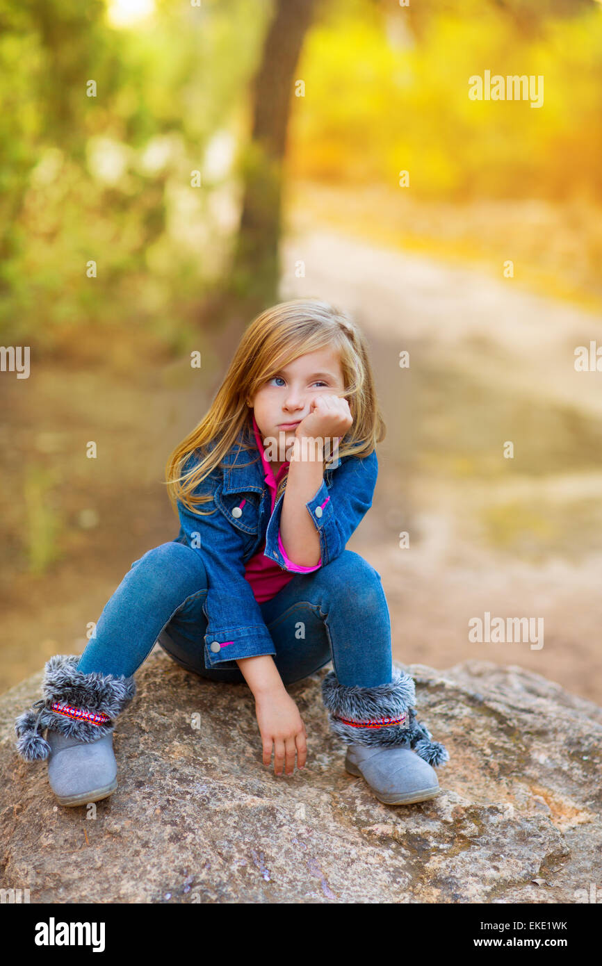 blond kid girl pensive bored in the forest outdoor Stock Photo - Alamy