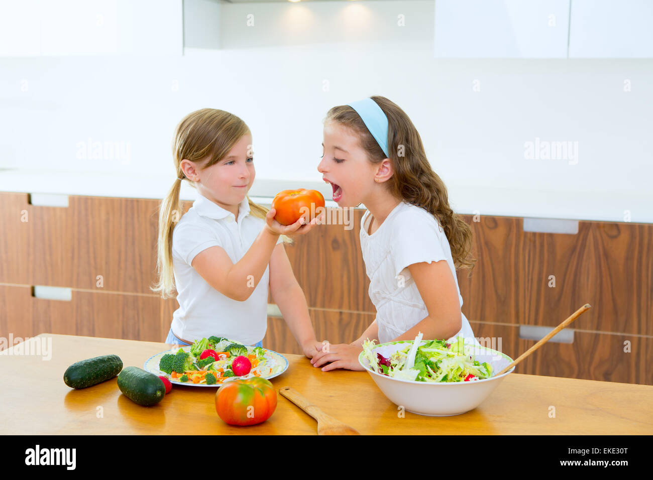Beautiful chef sisters at home kitchen preparing salad Stock Photo - Alamy