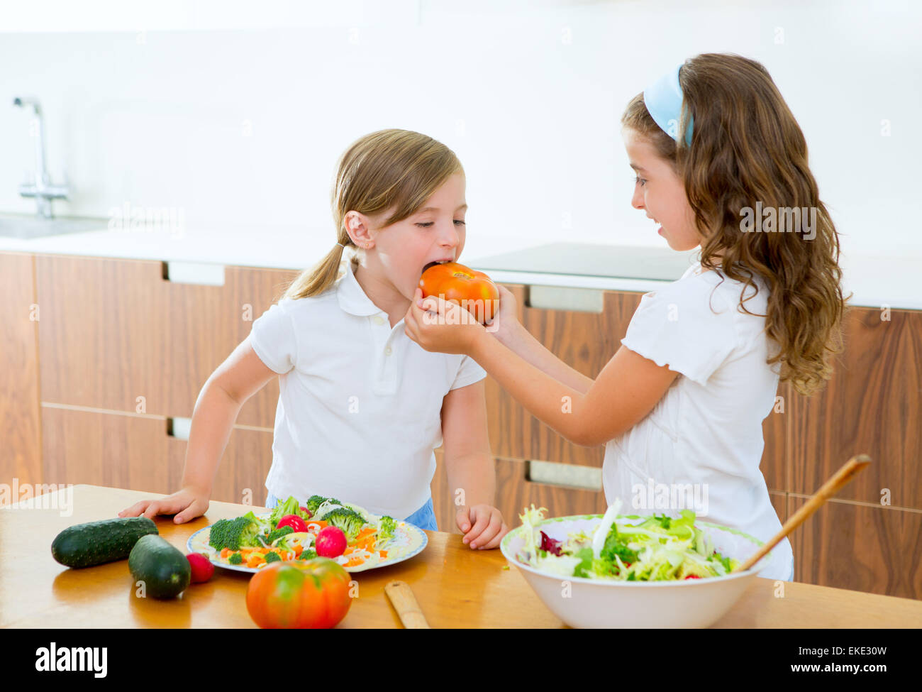 Beautiful chef sisters at home kitchen preparing salad Stock Photo - Alamy