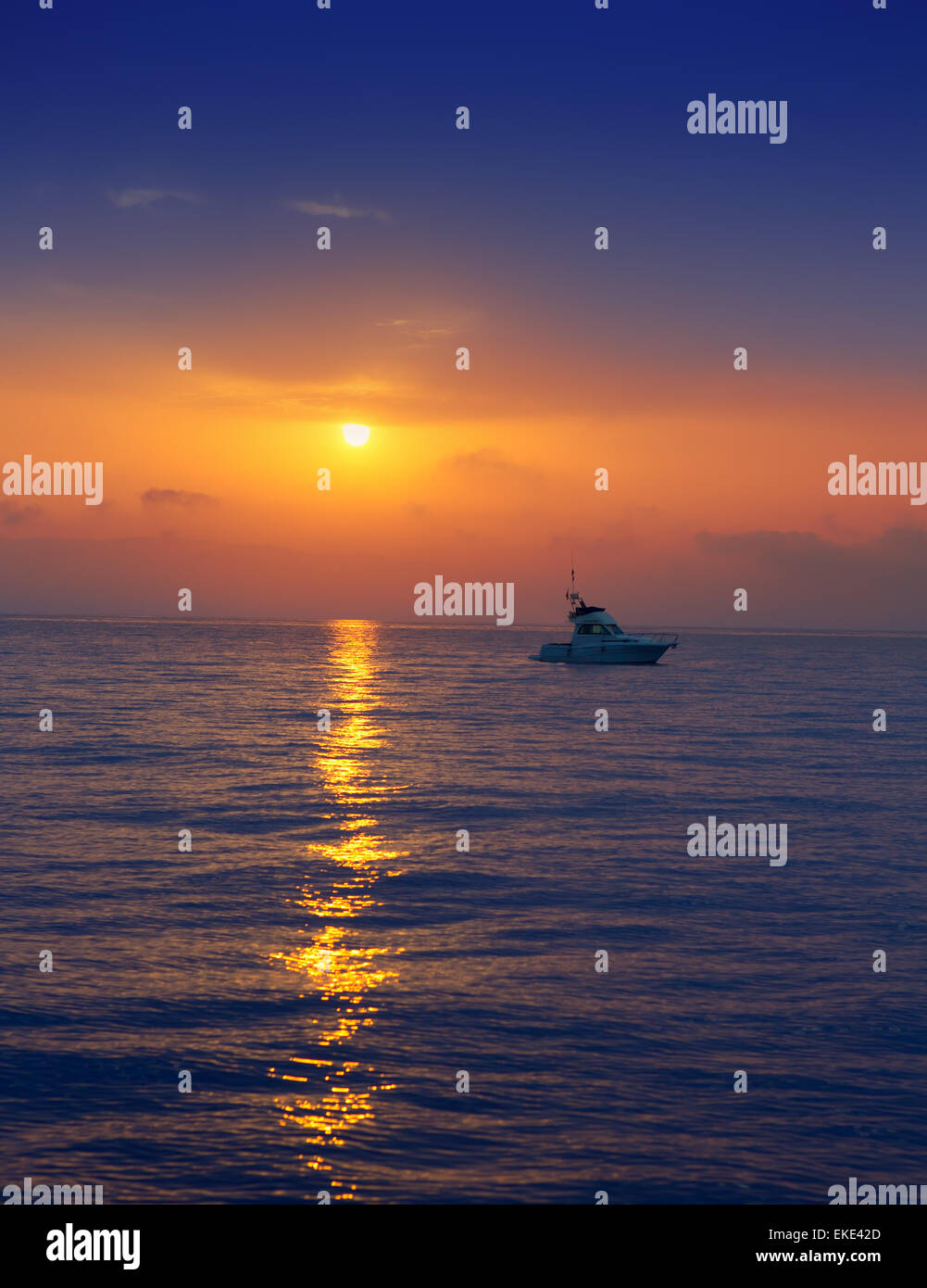 fisherboat in horizon on sunset sunrise at sea Stock Photo - Alamy
