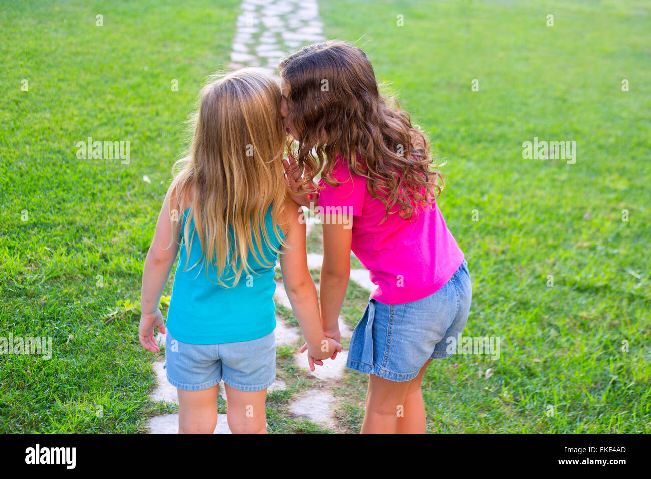 friends sister girls whispering secret in ear in garden Stock Photo - Alamy