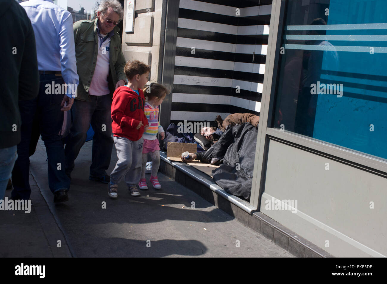 Children stare at sleeping homeless man in central London doorway Stock ...