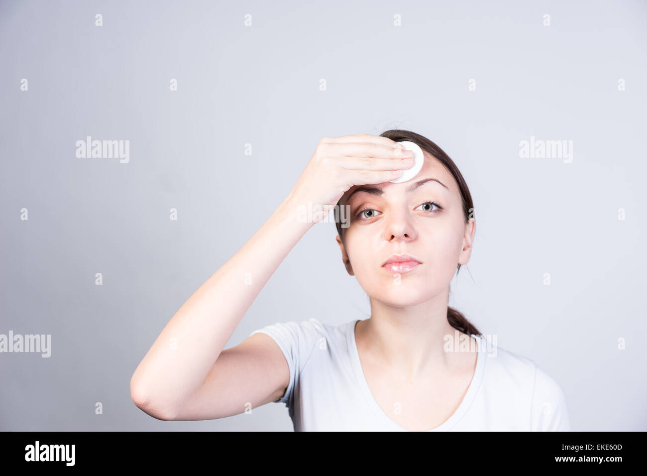 Close up Serious Young Woman Applying Astringent on her Forehead While ...
