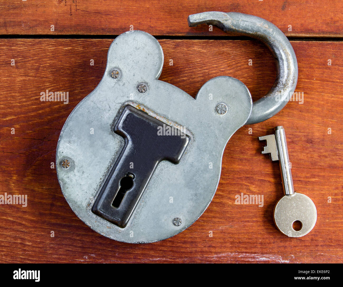 Four-lever padlock with key on dark wood background Stock Photo - Alamy