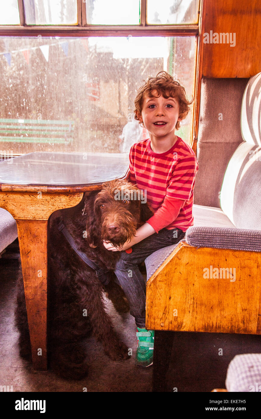 Five year old boy with his chocolate brown labradoodle dog Watercress ...